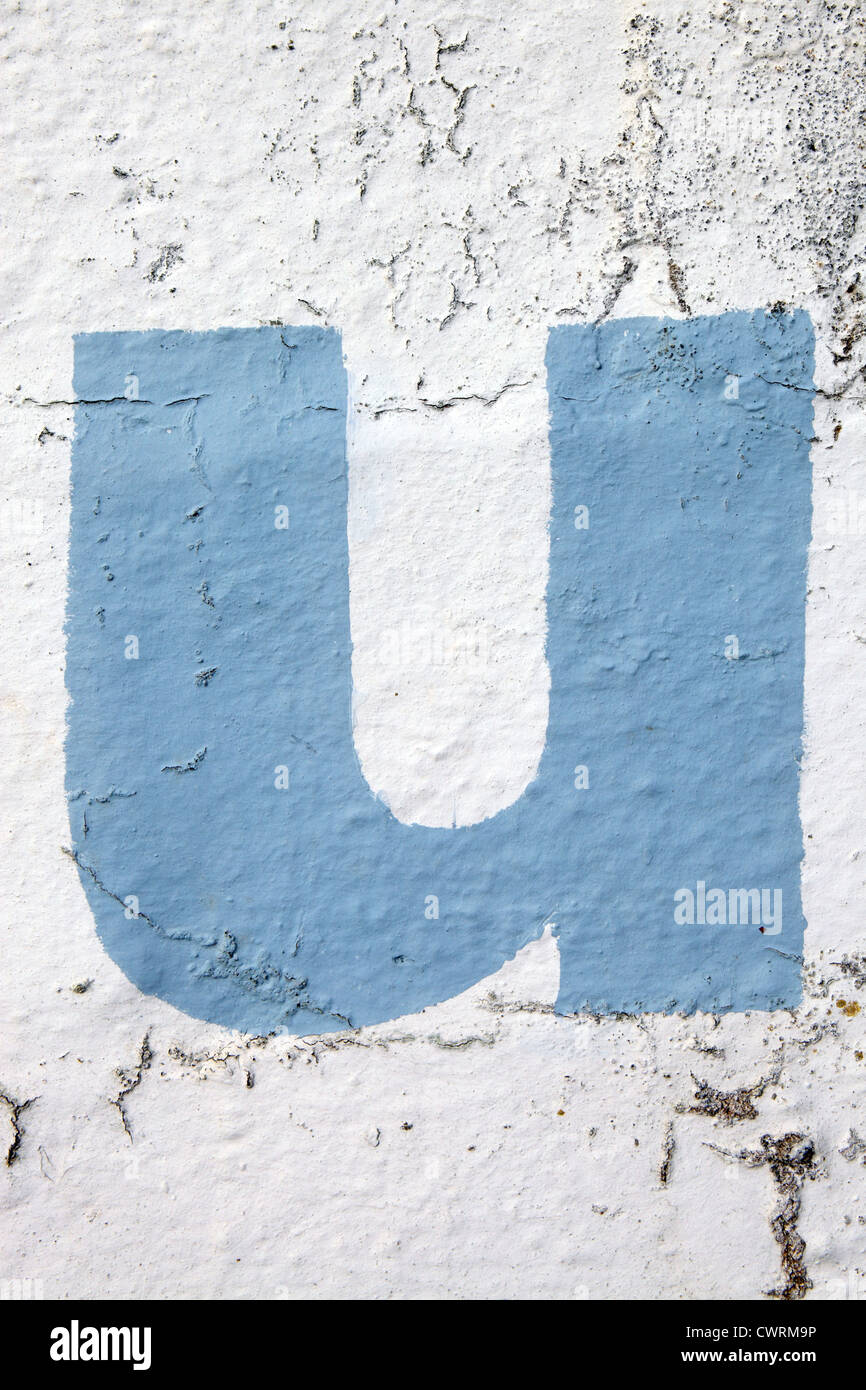 Minuscules lettre 'U' bleu ciel peinture au pochoir sur un mur ...