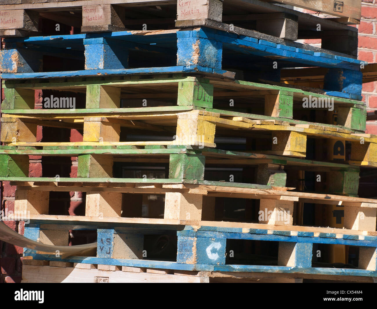 Les palettes en bois en différentes couleurs empilés après utilisation ...