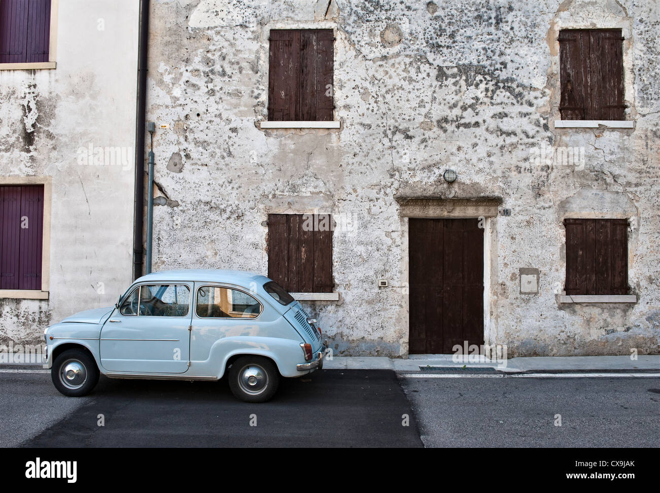 Une Fiat 500 d'époque devant la façade en ruine d'une ancienne maison ...