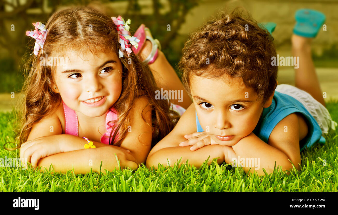 Photo de deux enfants heureux portant sur l'herbe verte fraîche, frère ...