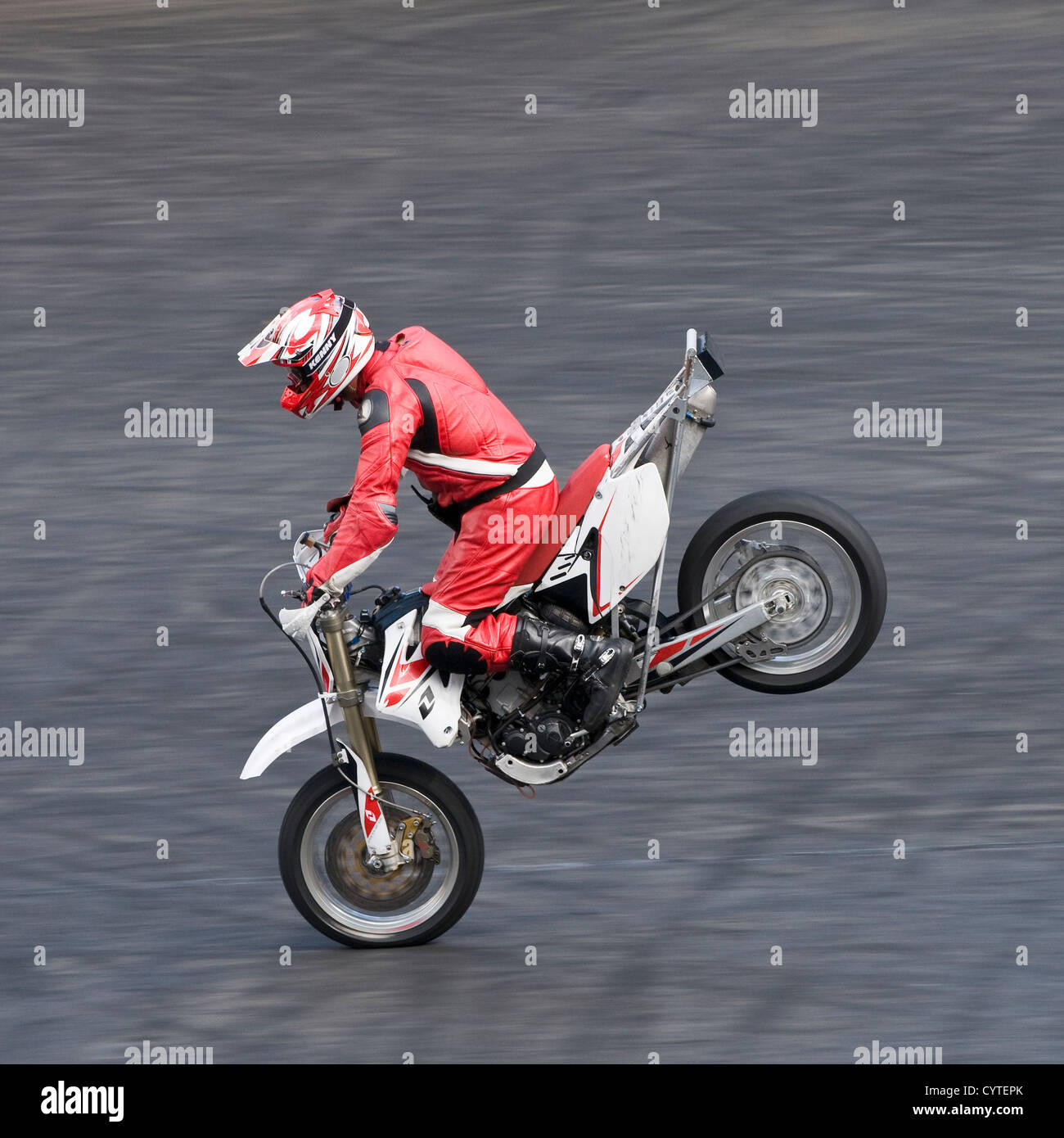 Cascadeur avant de faire un wheelie sur une moto. Vue depuis le côté ...