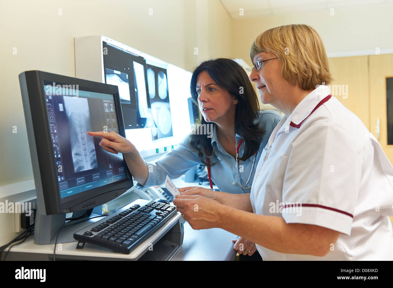 Médecin et radiologue à ensemble à un x ray image sur l'écran montrant ...