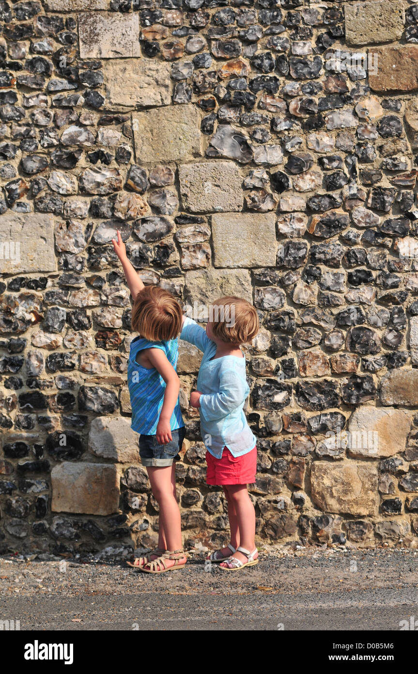 Petite fille EN FACE DE LA BARDEAUX FLINT MUR DE L'ÉGLISE SAINT-MARTIN ...
