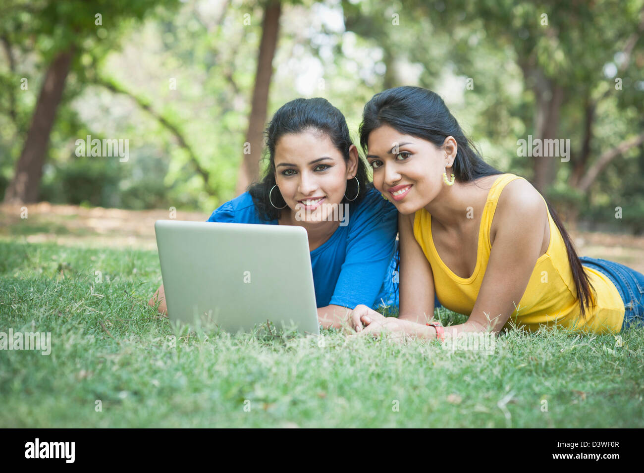 Des amis à l'aide d'un ordinateur portable dans un parc, Lodi Gardens ...