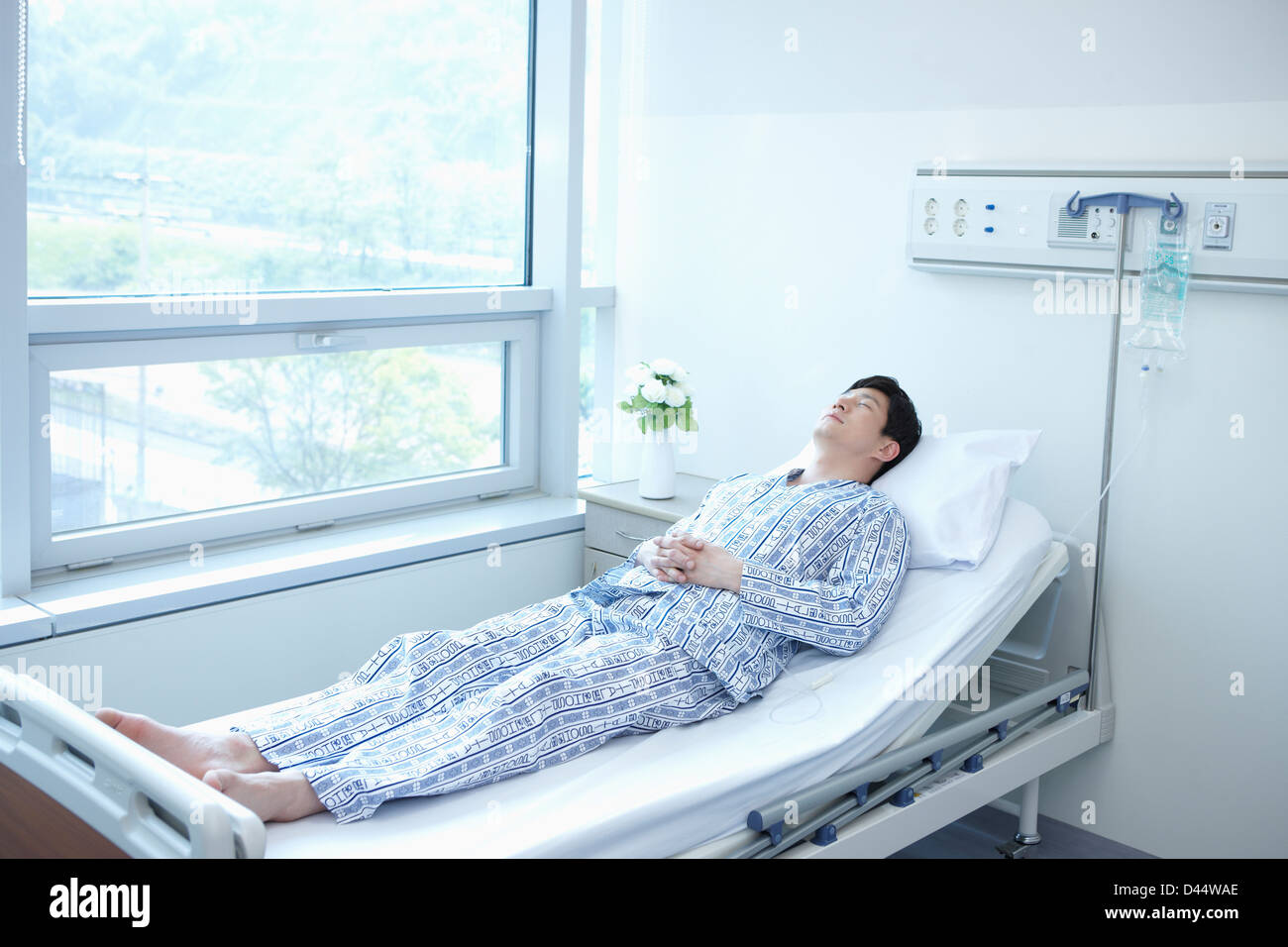Un patient allongé sur le lit dans la chambre d'hôpital de façon ...