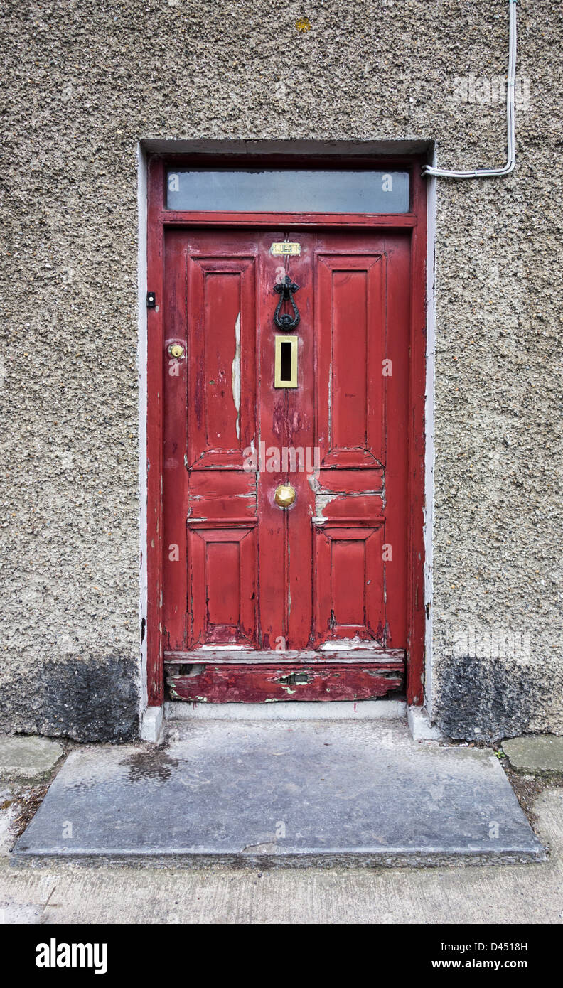 Une porte rouge en difficulté avec l'écaillage de la peinture dans une ...