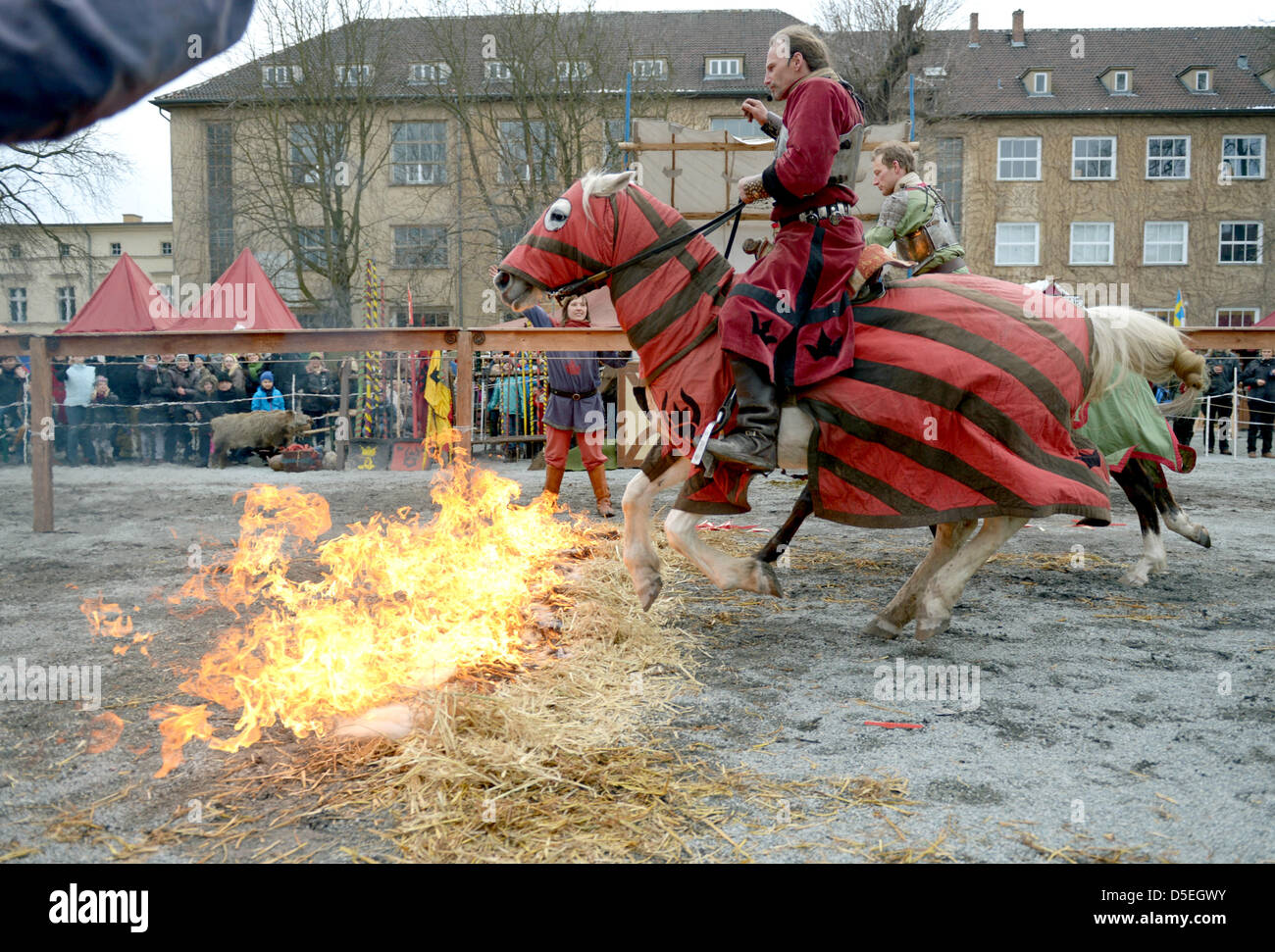 Un homme habillé comme un chevalier médiéval saute avec son cheval d ...