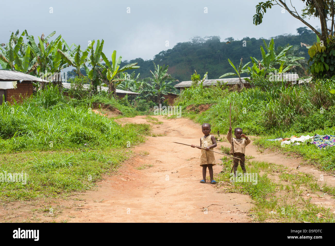 Deux enfants africains en haillons sur un chemin de terre à l'extérieur ...