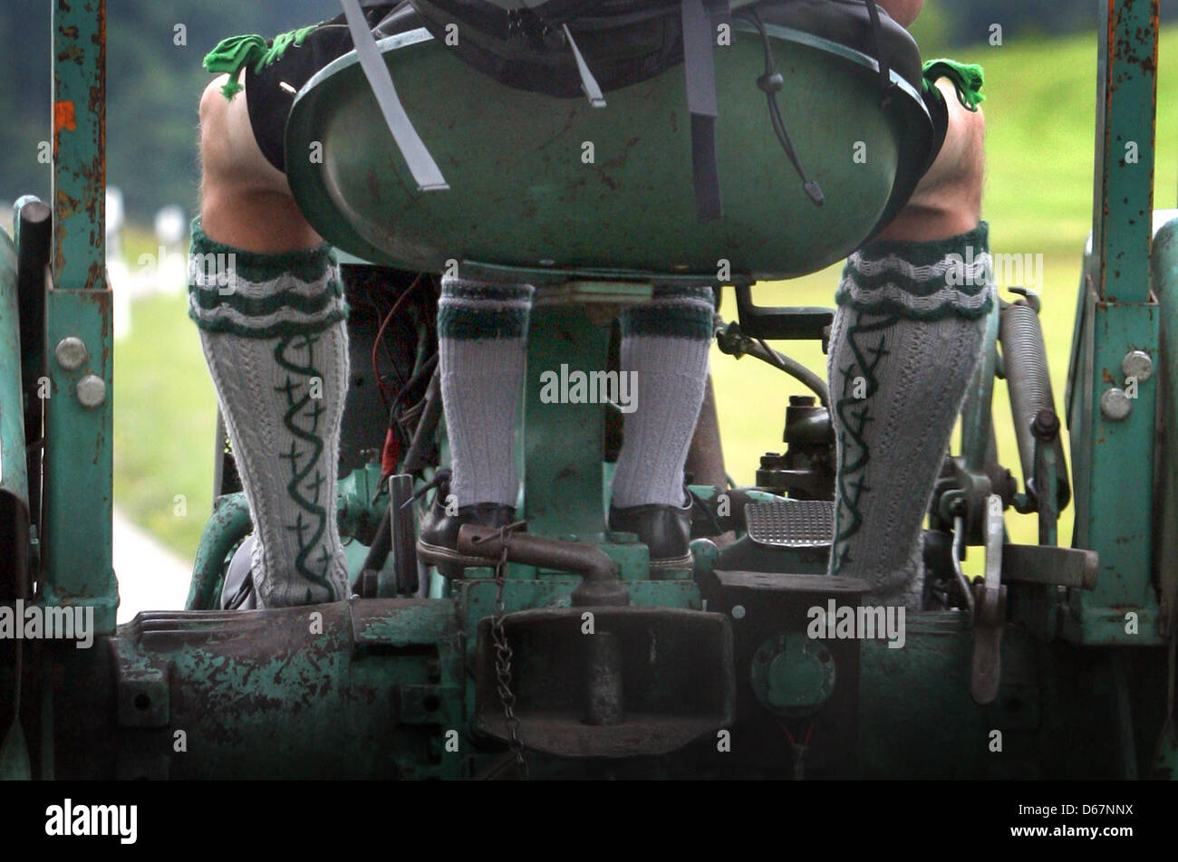 En costume traditionnel bavarois, un homme conduit un tracteur avec son ...