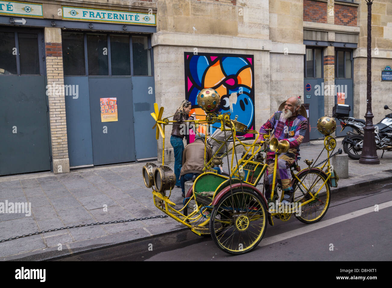 Paris, France. Un homme pousse un étrange pousse-pousse à travers les ...