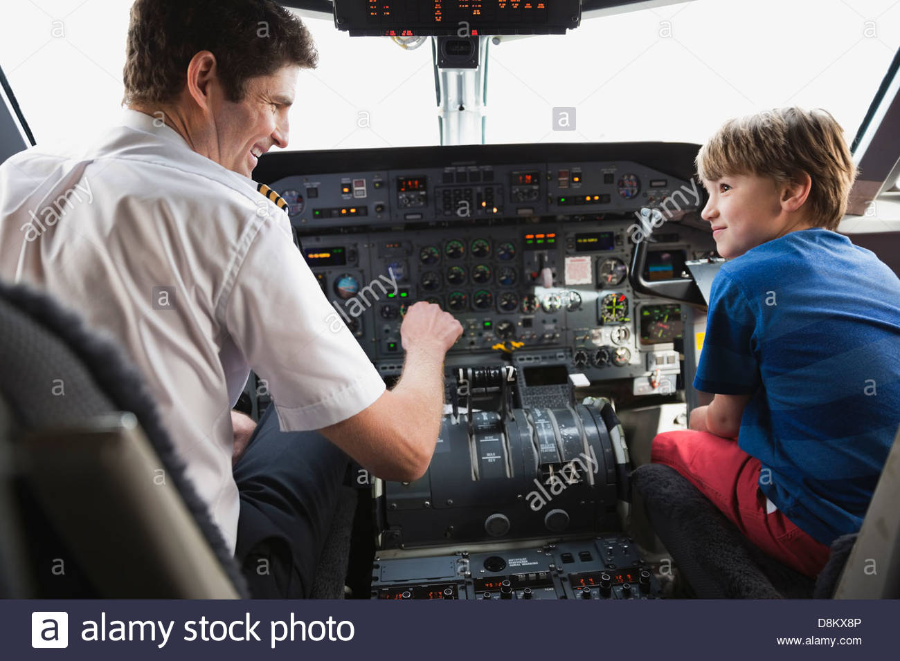 Garçon assis avec pilot in airplane cockpit Photo Stock - Alamy