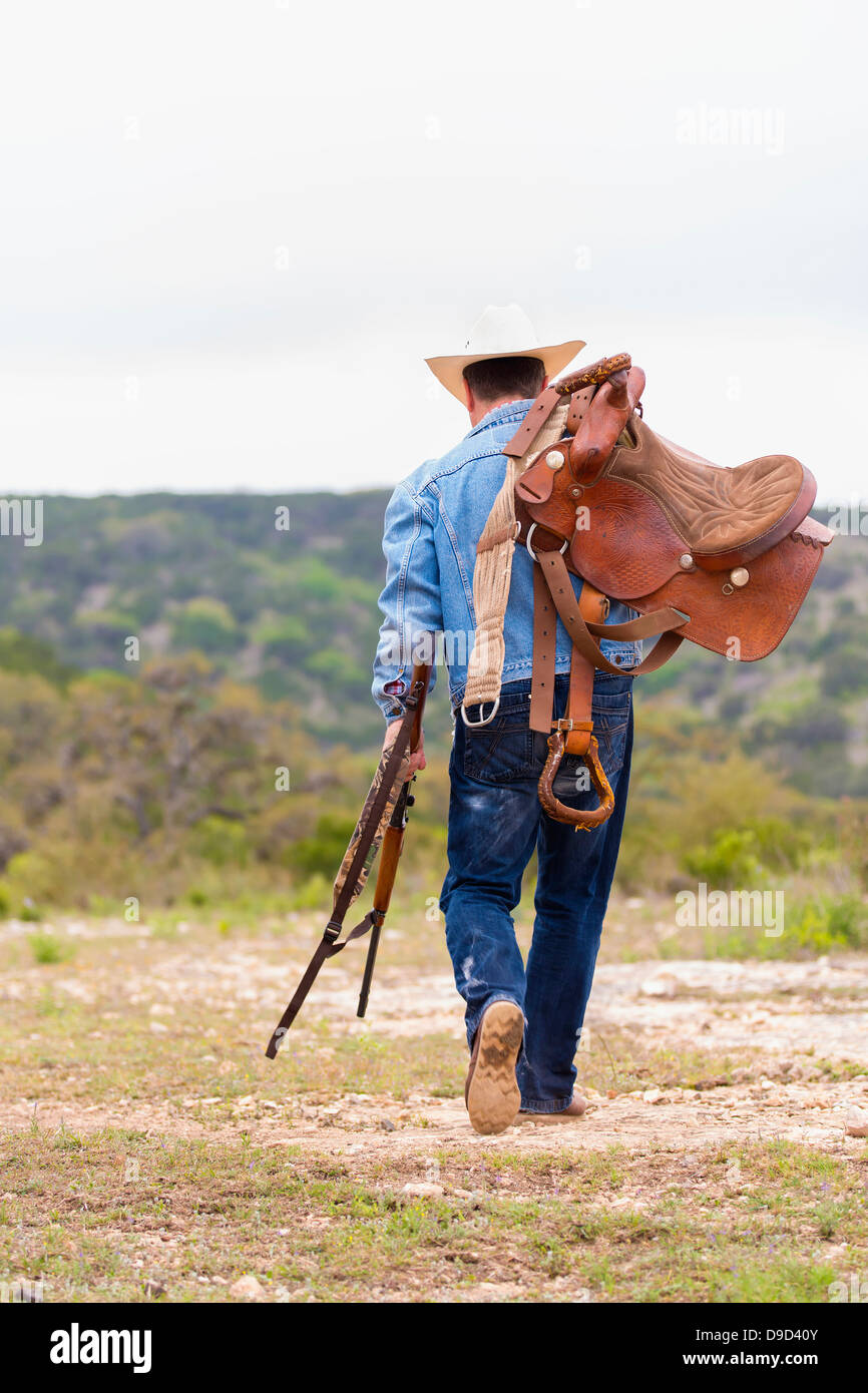 Cow boy marchant avec fusil et selle Banque de photographies et d ...