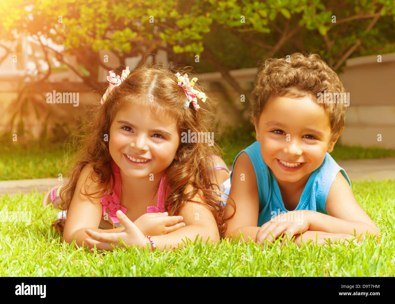 Deux enfants heureux de se coucher sur l'herbe verte, frère et sœur ...