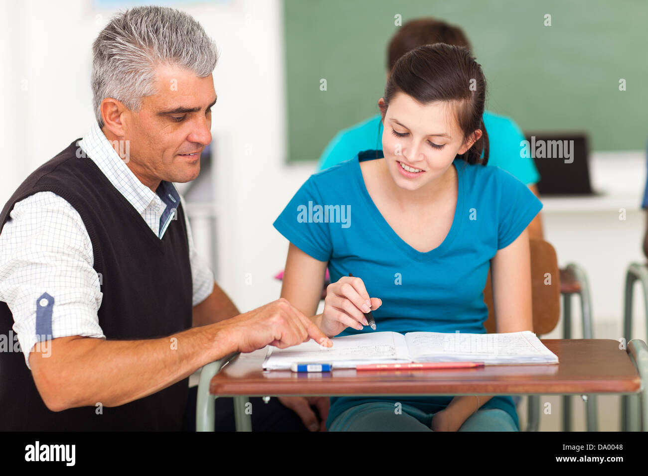 Professeur de lycée à maturité aider un étudiant avec son travail en ...