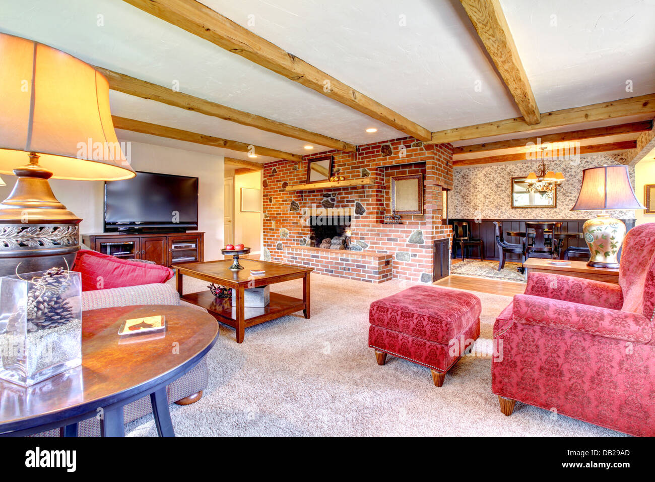 Intérieur salon avec cheminée en briques, poutres apparentes en bois et ...