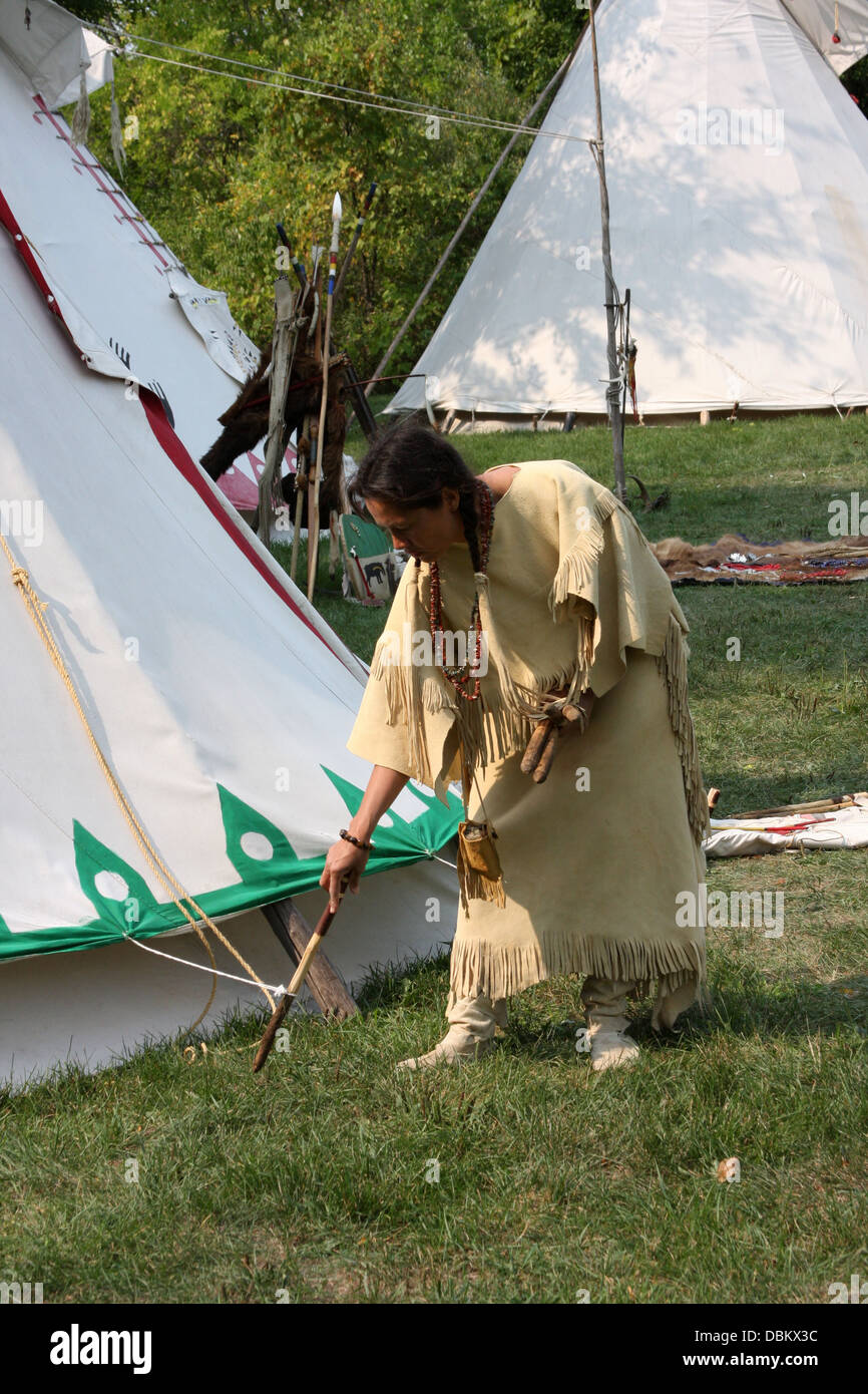 Native American Indien Lakota woman pulling stakes à partir d'un tipi ...