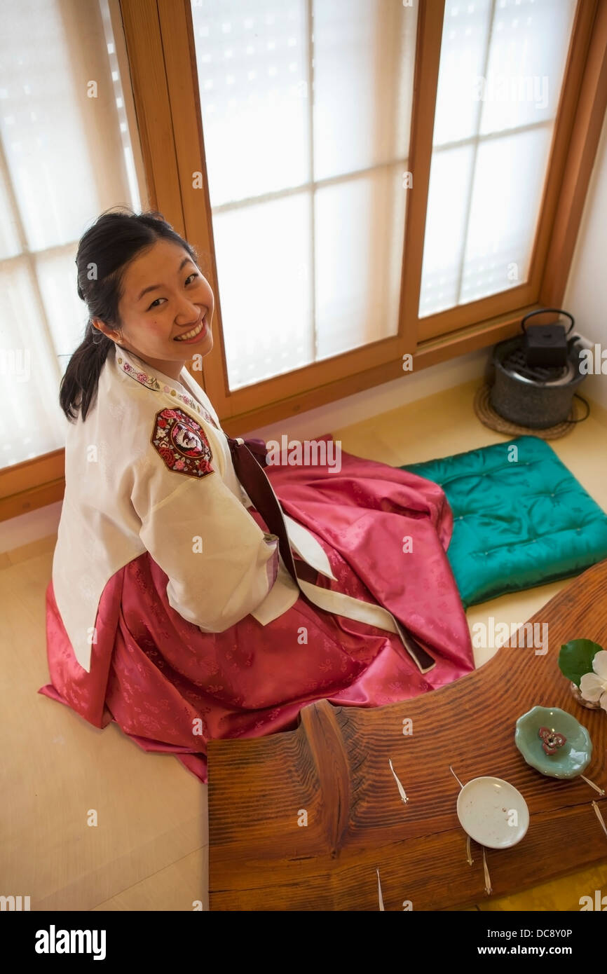 Une femme assise portant un beau Hanbok traditionnel dans Bokchon Hanok ...