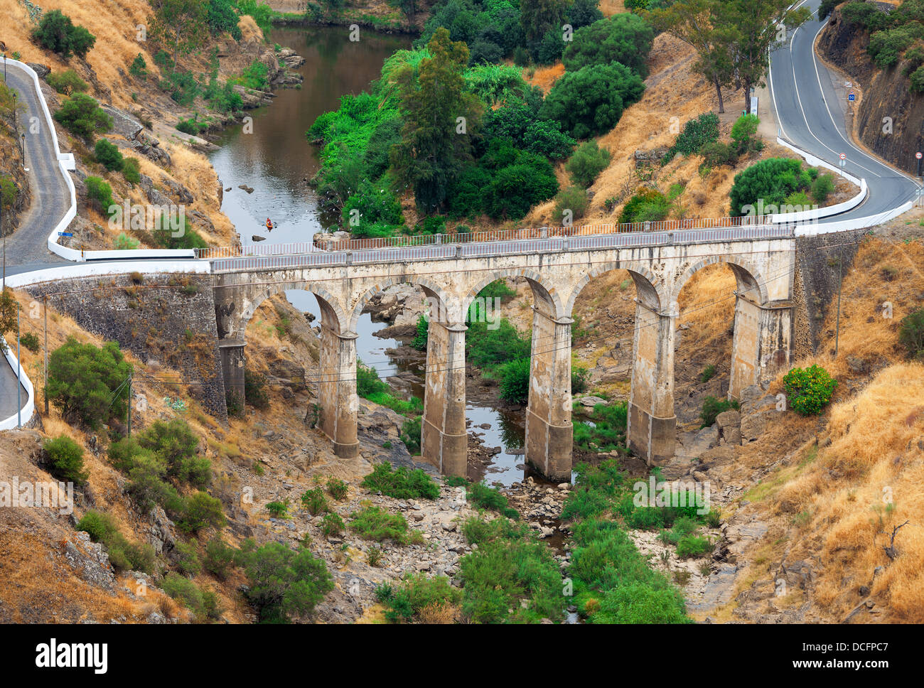 Pont routier voûté avec des voûtes en pierre traversant une rivière lit ...