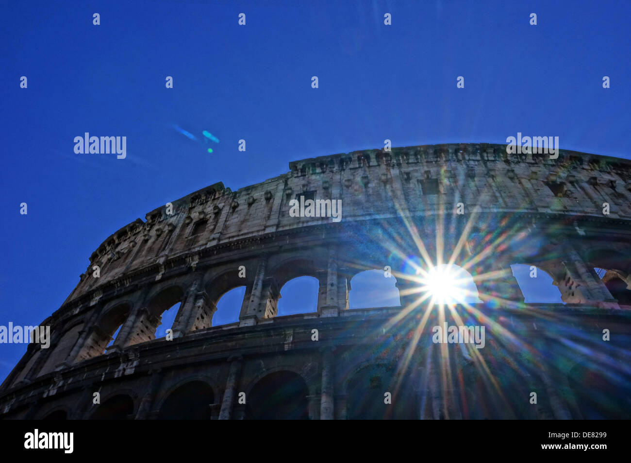 Le soleil brille à travers une des ouvertures dans le Colisée à Rome ...
