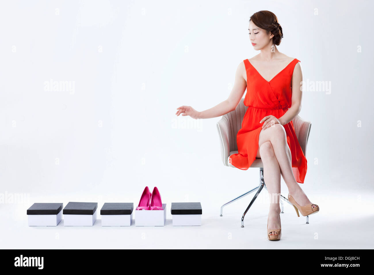 Femme assise sur une chaise Banque de photographies et d’images à haute résolution - Alamy