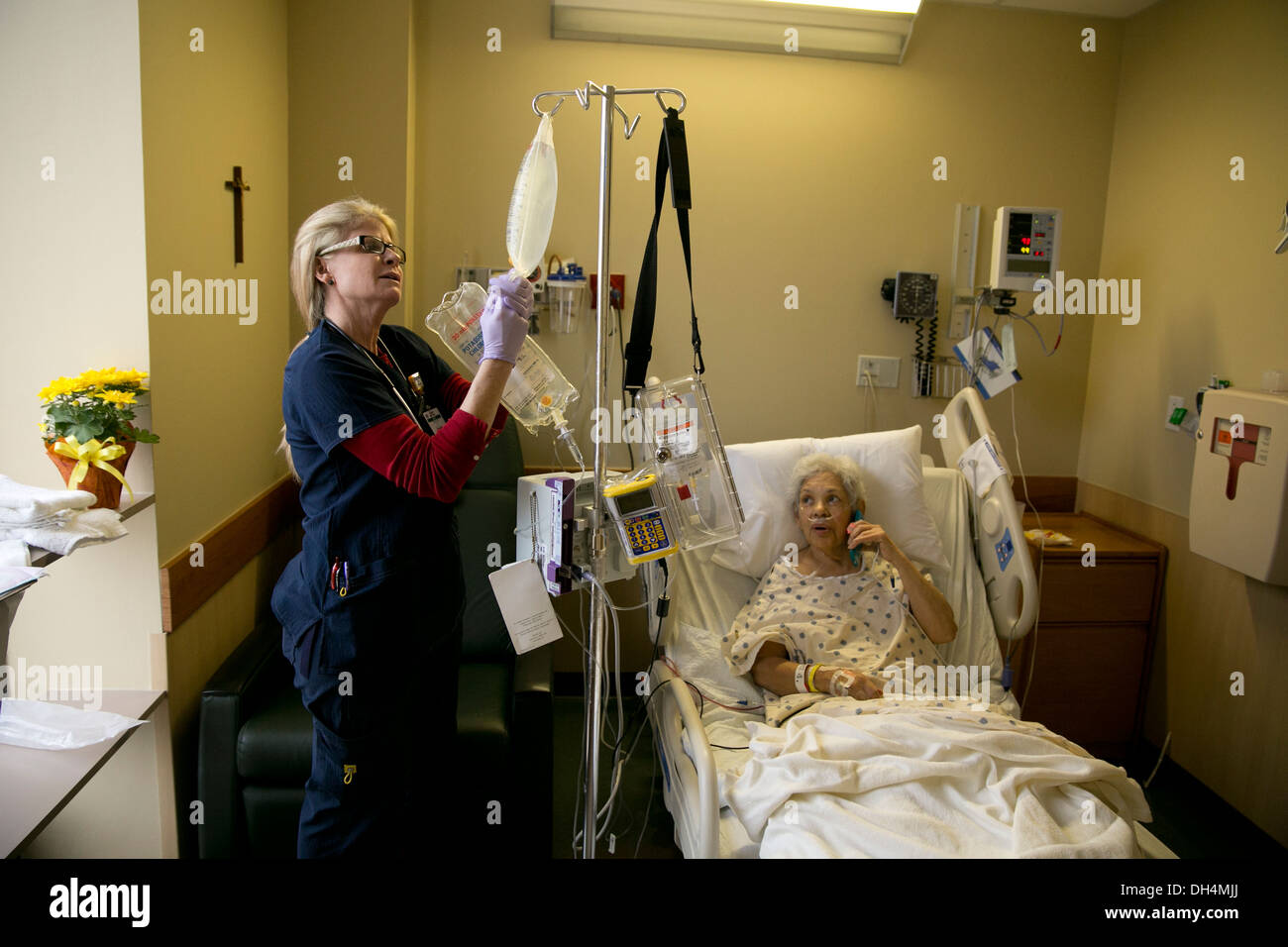 Infirmière blanc femme vérifie le liquide IV sac de 74 ans Hispanic ...