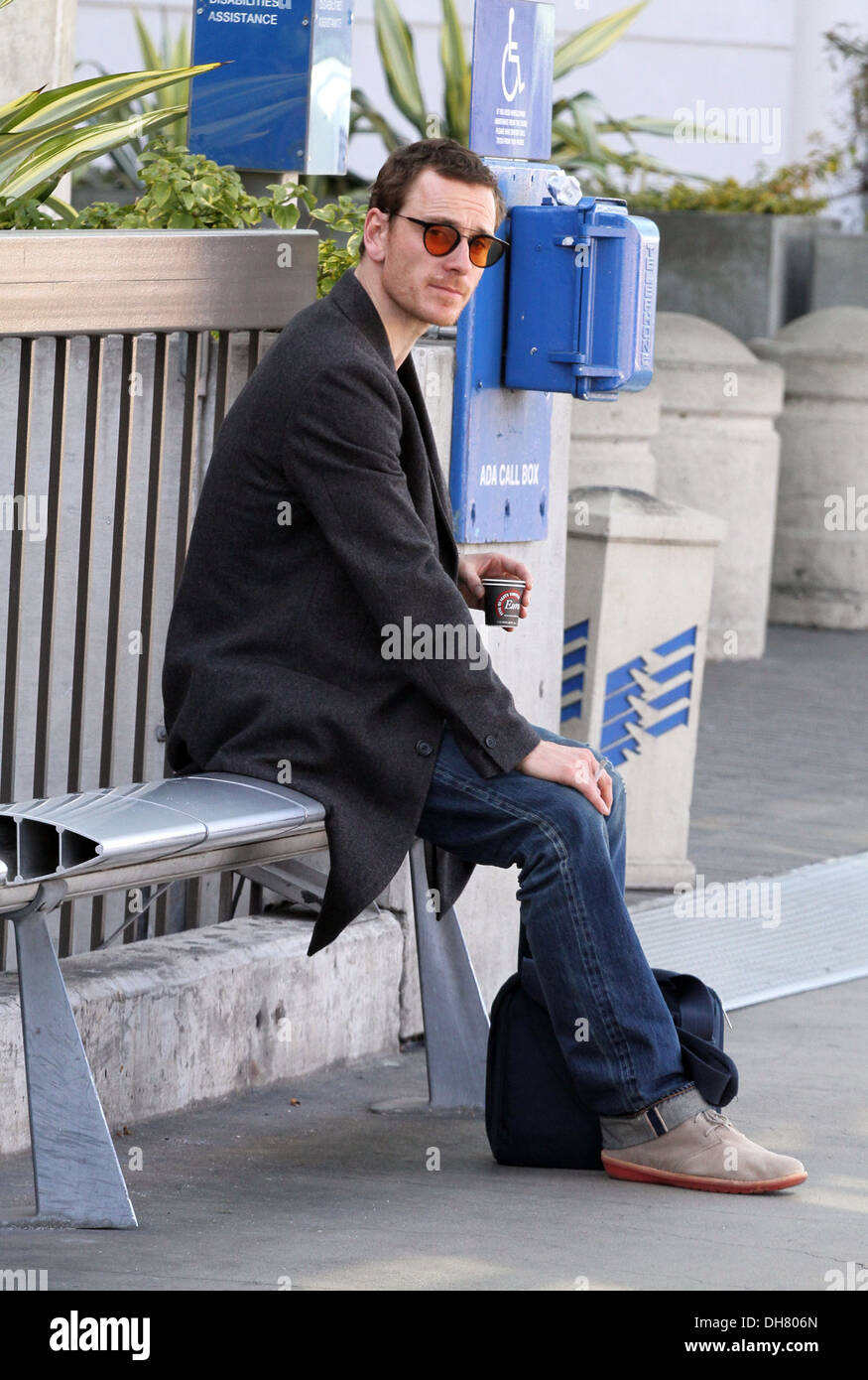 Michael Fassbender est assis sur un banc et fume une cigarette avant de ...