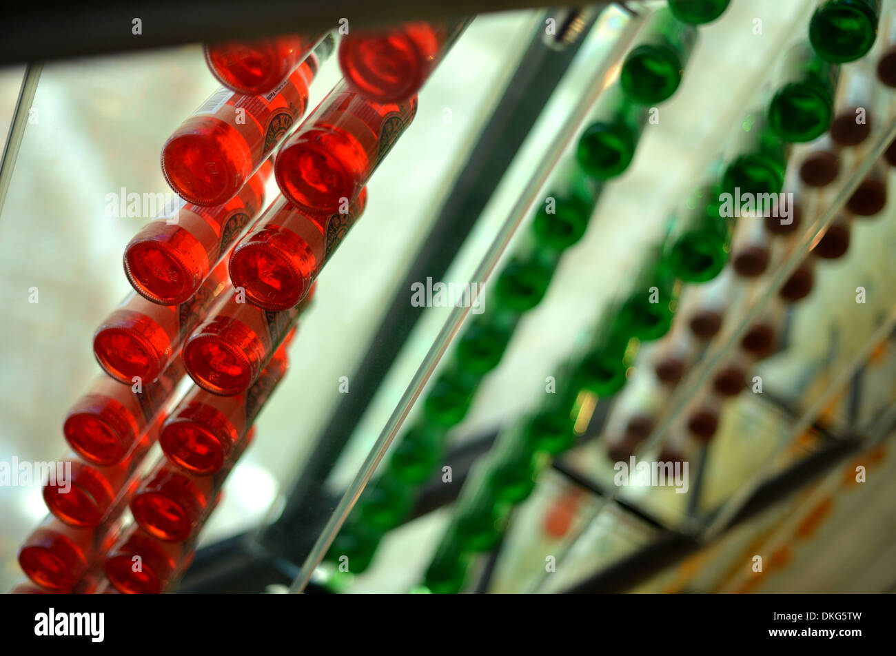 Des rangées de bouteilles de boissons gazeuses sur étagères en verre de ...
