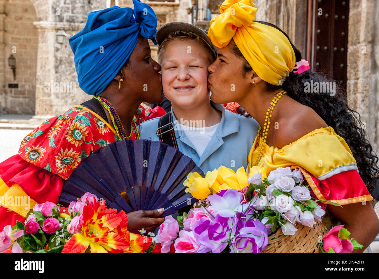 Les femmes cubaines en costume traditionnel s'embrasser un touriste ...