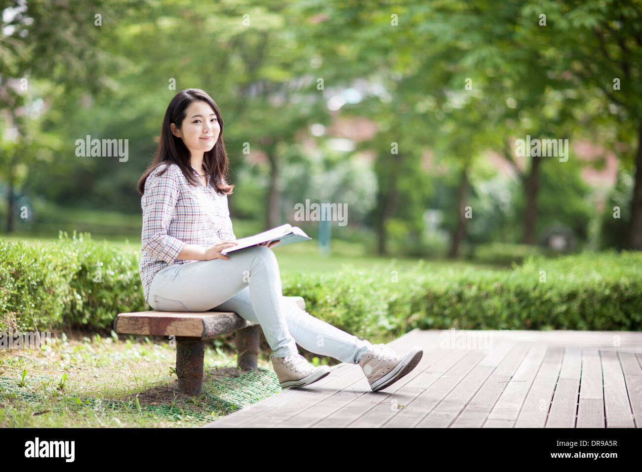 Une femme assise sur un banc Banque de photographies et d’images à haute résolution - Alamy