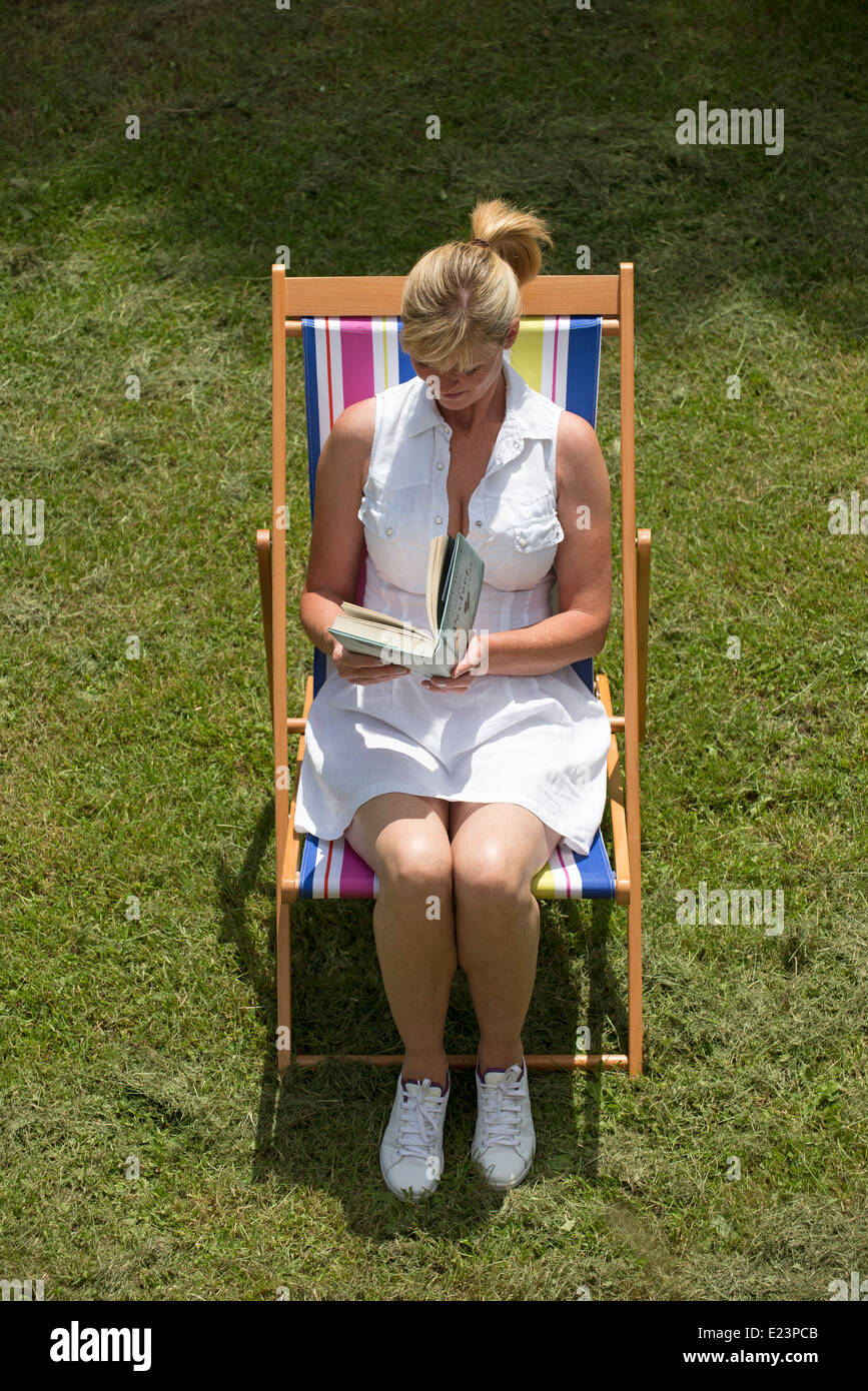 Femme Assise Dans Un Livre De Lecture De Chaise Longue Banque De