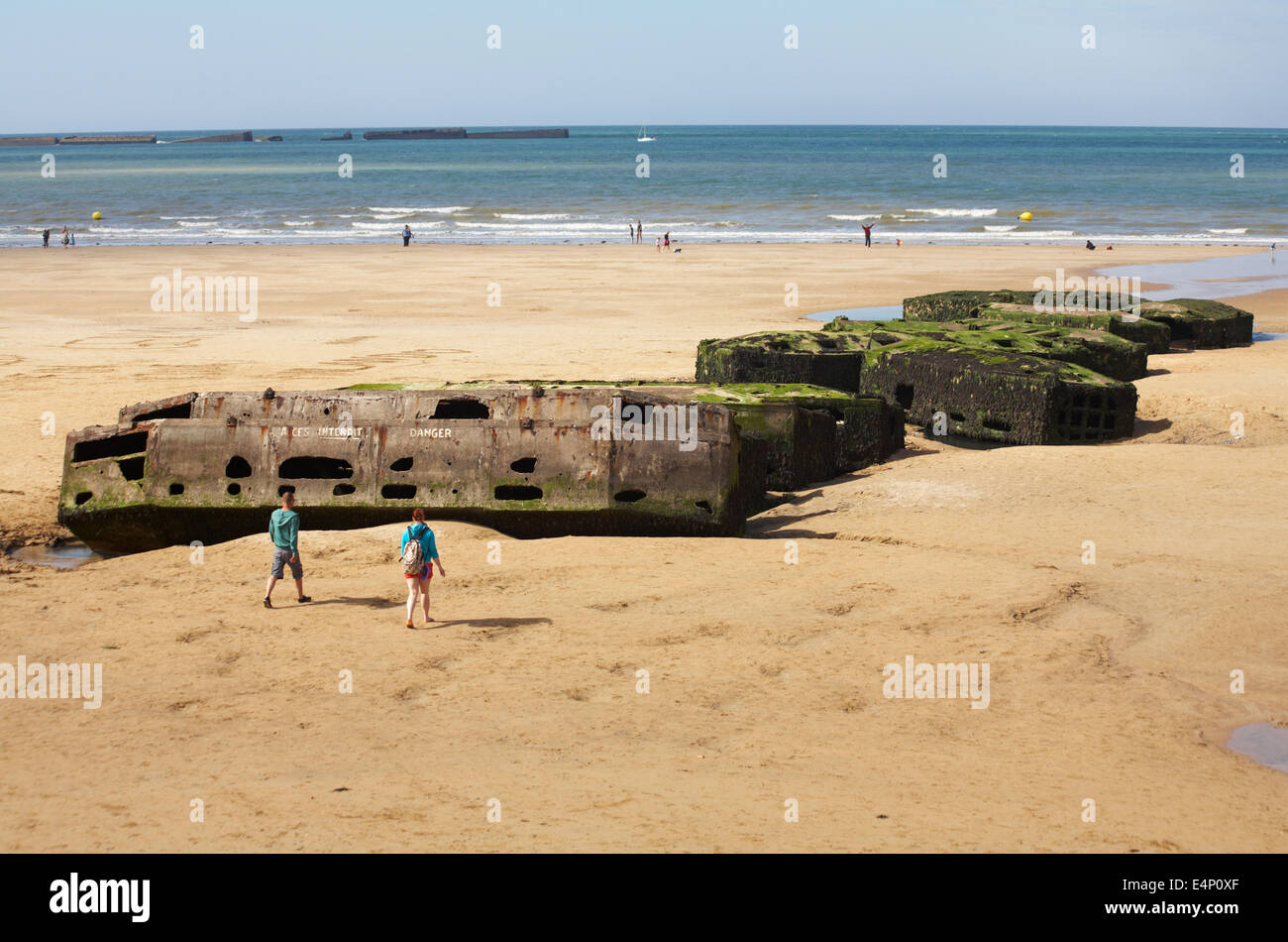Les visiteurs à explorer les vestiges de Mulberry Harbour sur la plage ...