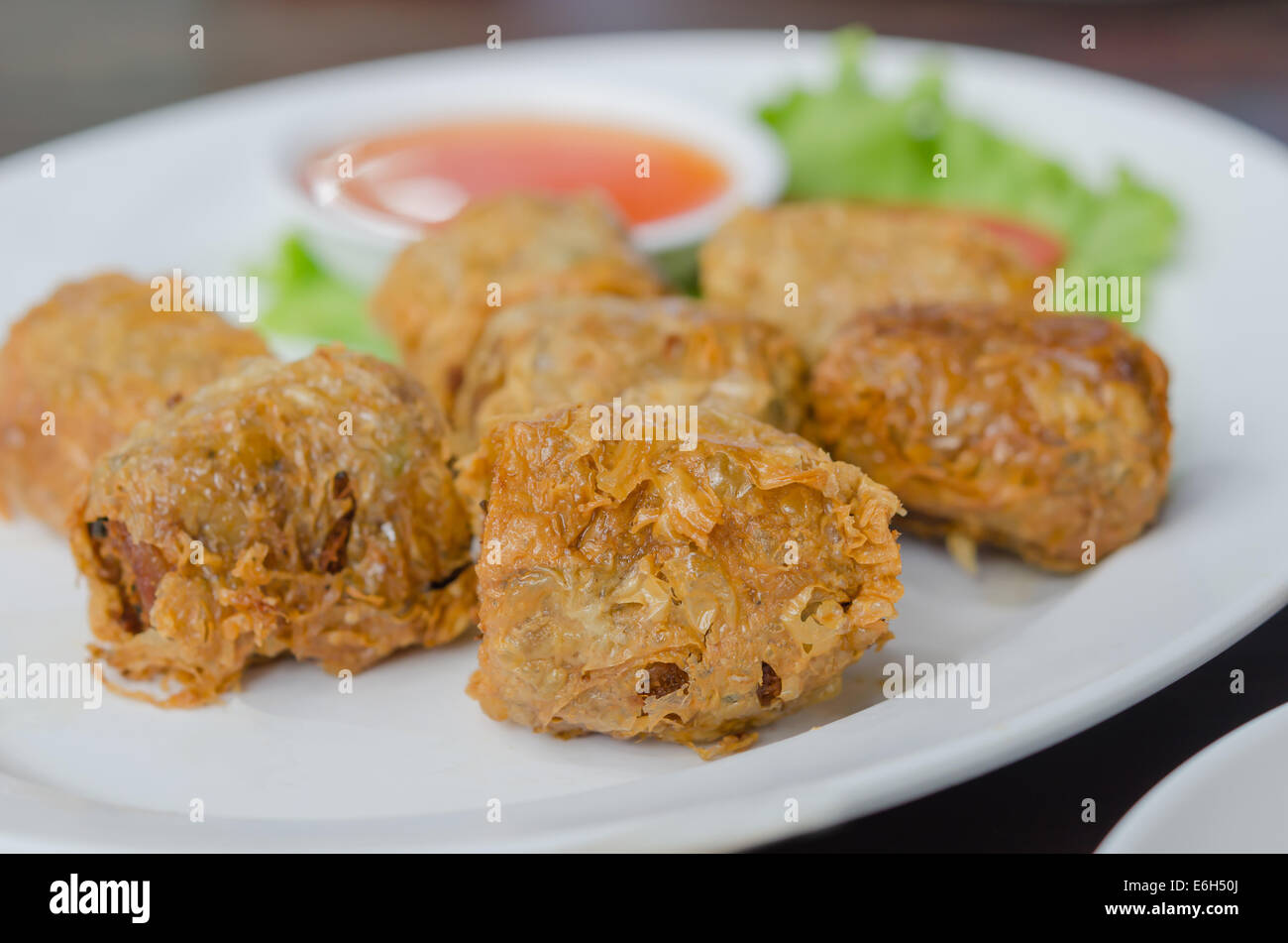 Close up rouleau de chair de crabe frit gâteau sur un plat blanc ...