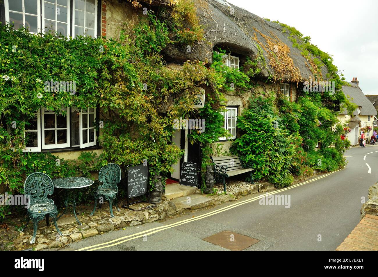 Un pub dans un village anglais avec un toit de chaume et table en fer ...