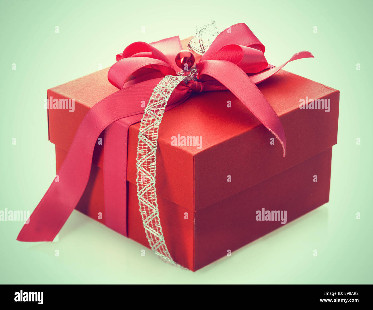 Boîte cadeau rouge attaché avec une boucle décorative pour célébrer ...