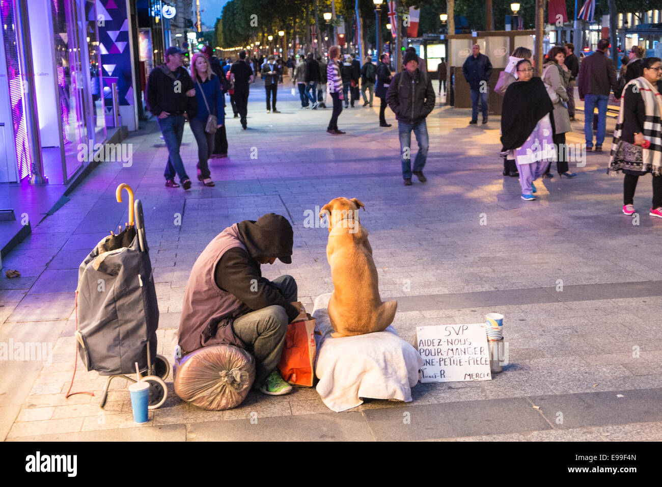 Homeless man with dog mendier le long de l'Avenue des Champs Élysées ...
