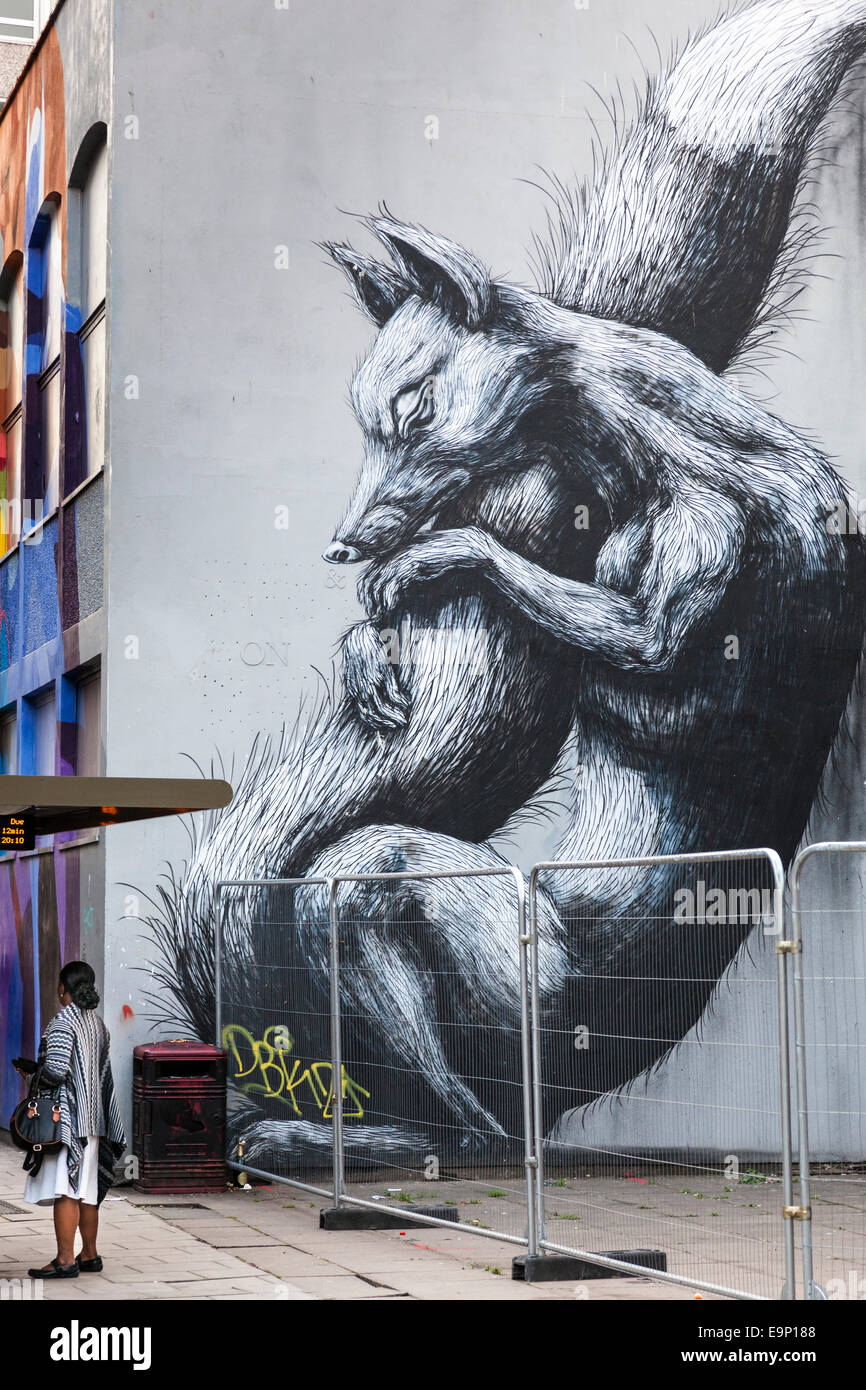 Une femme en attente à un arrêt de bus est dominé par une gigantesque ...
