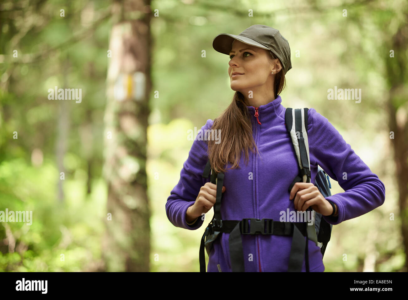Jeune femme randonneuse avec sac à dos sur une piste forestière dans ...
