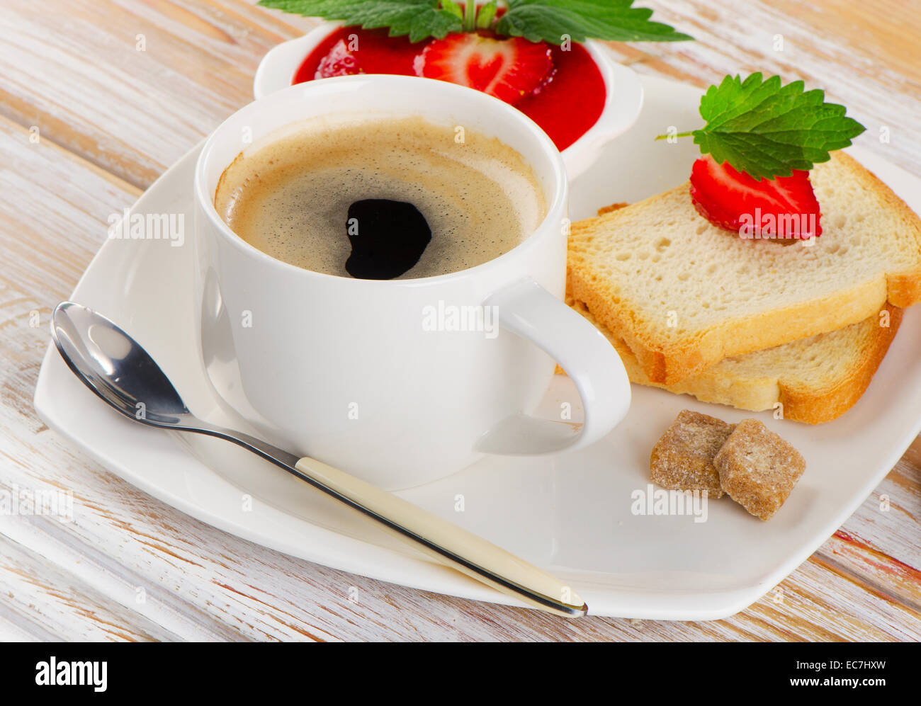 Le petit-déjeuner avec du pain grillé, de la confiture de fraise et de café chaud. Selective ...