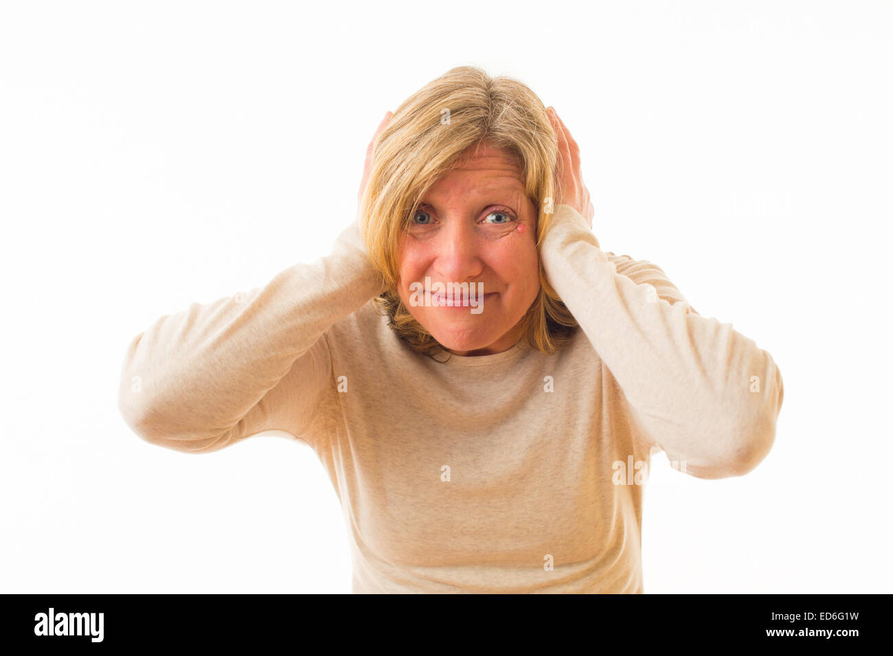 Une femme de race blanche de 40 ans couvrant ses oreilles avec ses ...