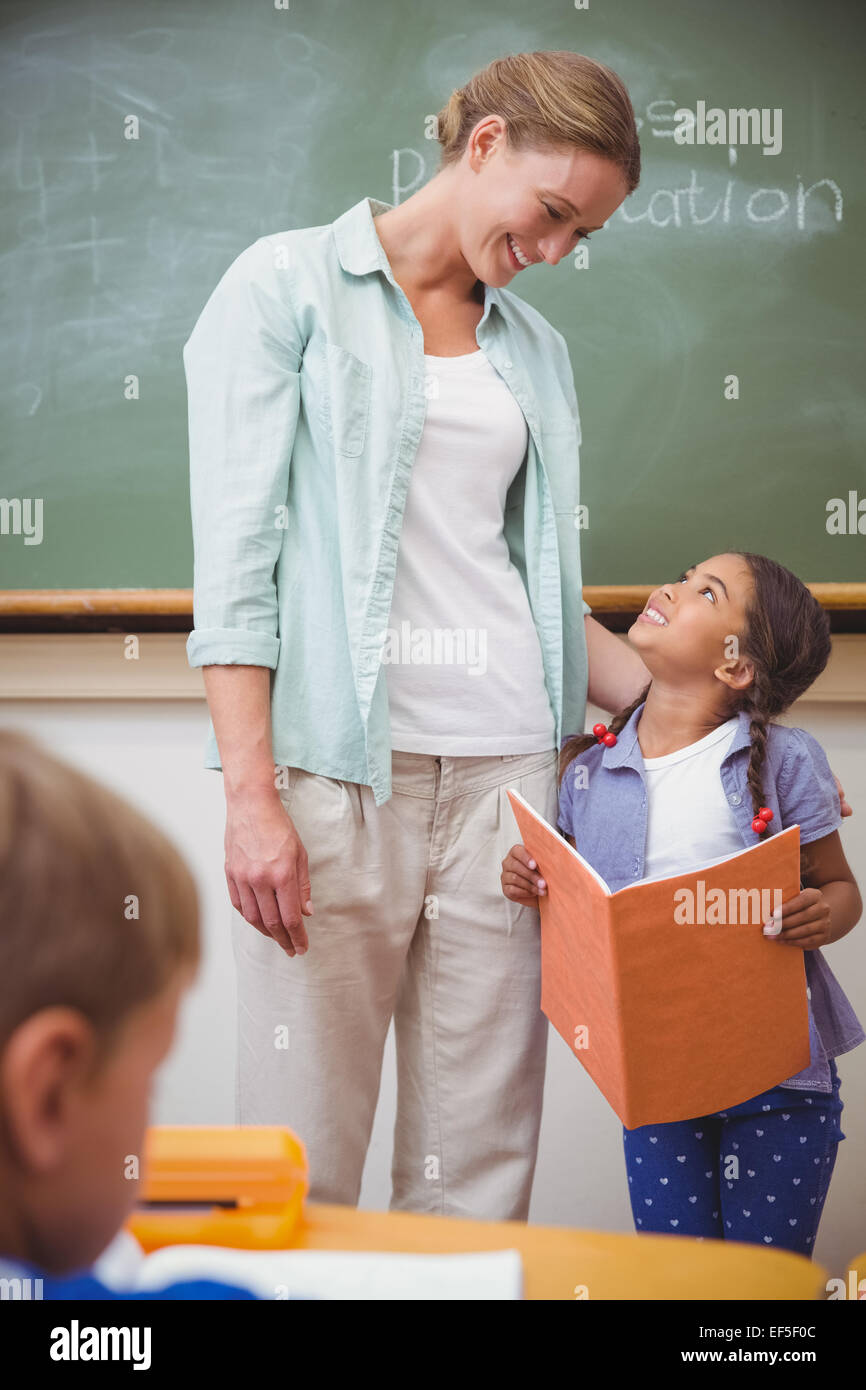 Cute smiling élève à son professeur lors d'une présentation en classe ...