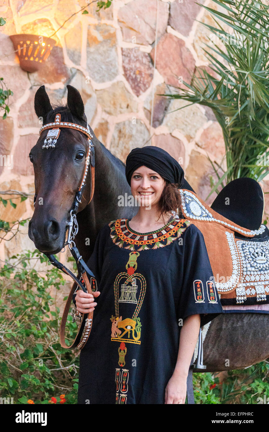 Cheval Arabe femme robe traditionnelle standing next jument alezane le ...