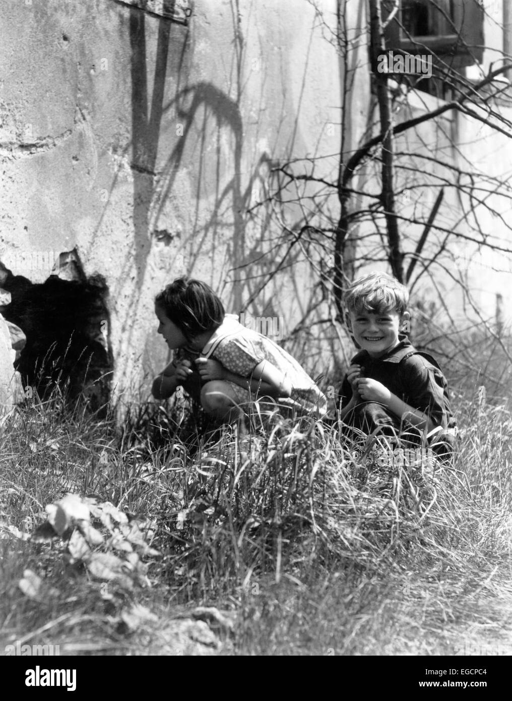 1930 2 LES ENFANTS À CÔTÉ DE L'ANCIEN BÂTIMENT GIRL PEEKING DANS LE ...