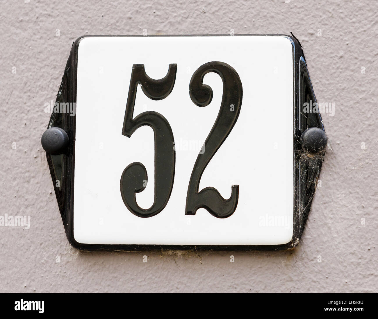 Signe de la maison au numéro 52 en caractères noirs sur un mur gris ...