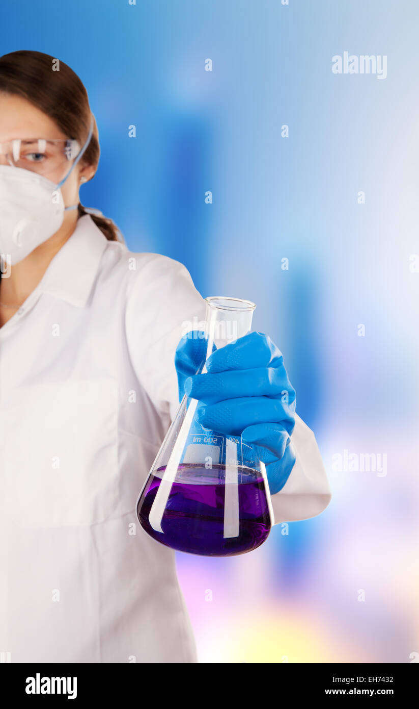 Femme en tenue de laboratoire produit chimique liquide dans un flacon ...