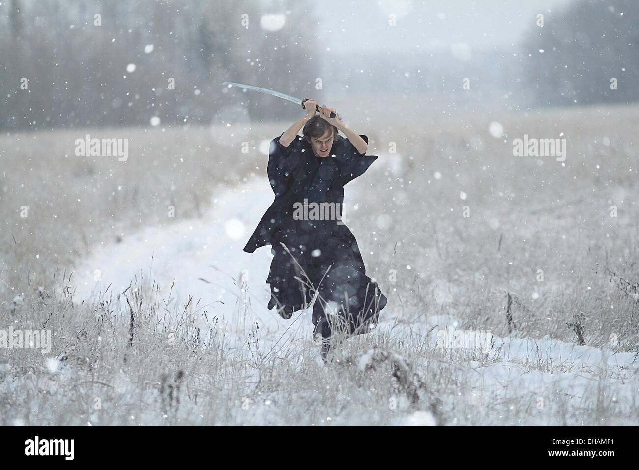 L'exécution de samurai vêtu d'un kimono dans un champ d'hiver vêtu de ...