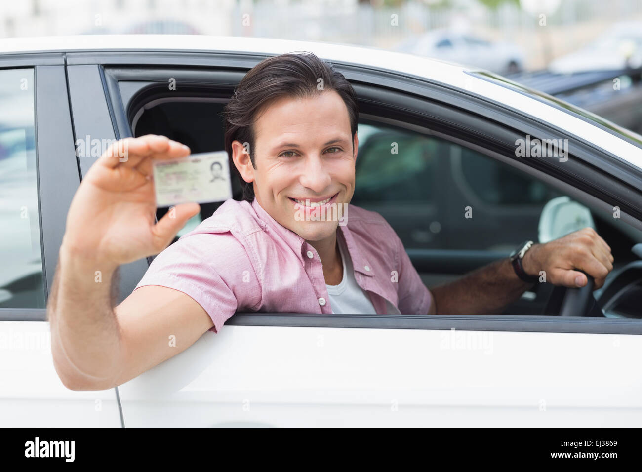 L'homme souriant et tenant son permis de conduire Photo Stock - Alamy