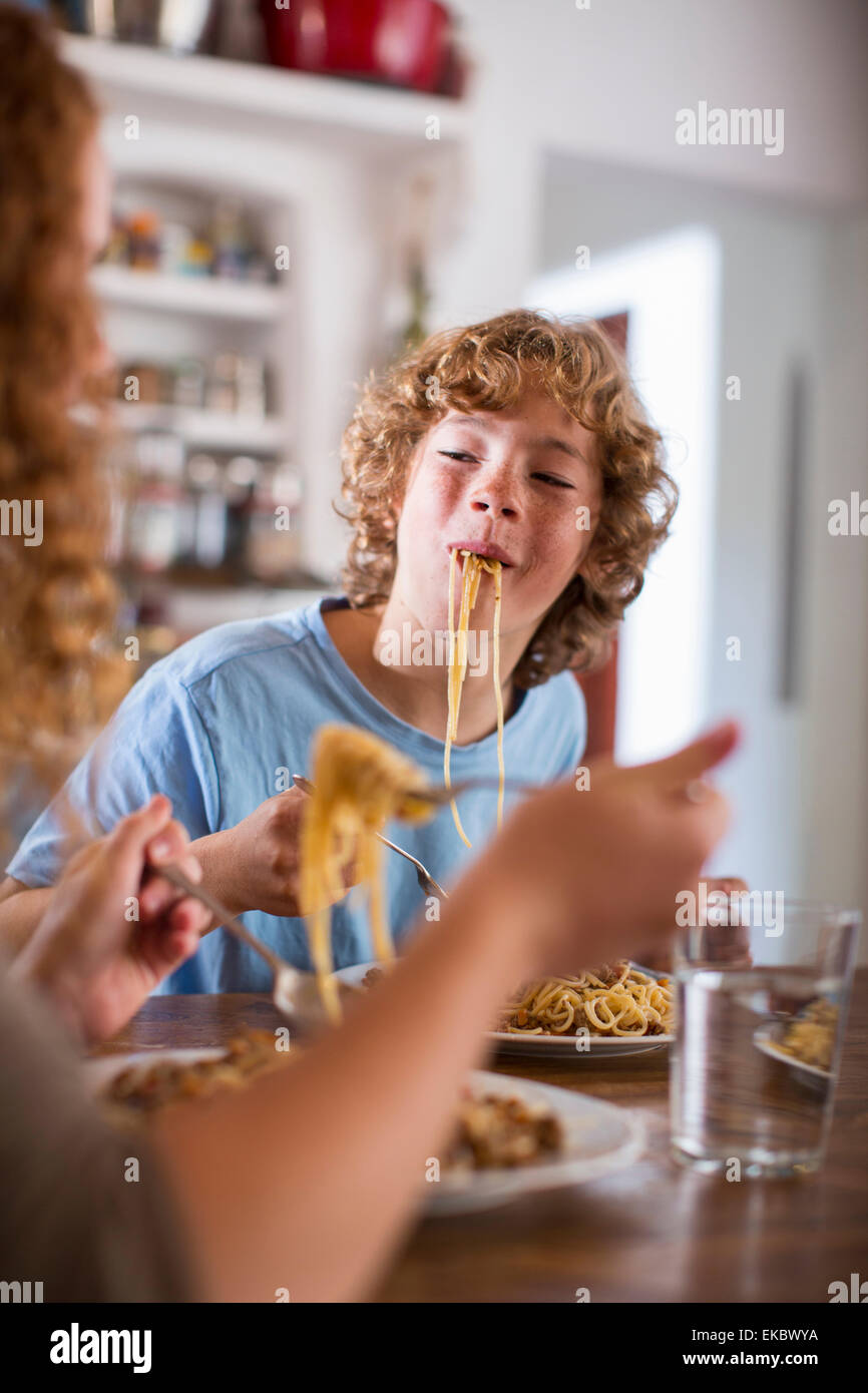 Teenage boy eating spaghetti à table à manger Photo Stock - Alamy