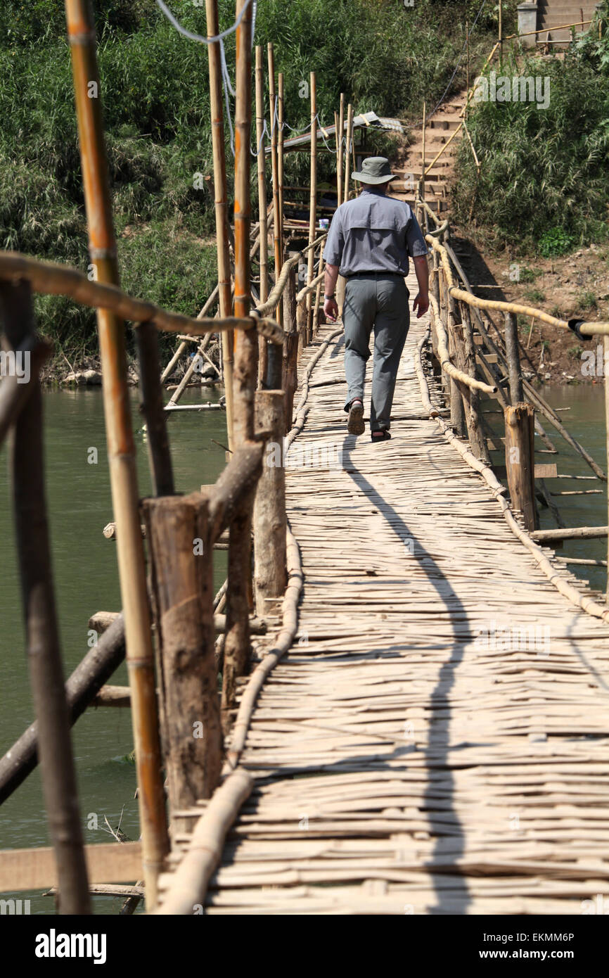 Traversée d'un pont de bambou voyageur sur la rivière Nam Khan à Luang ...