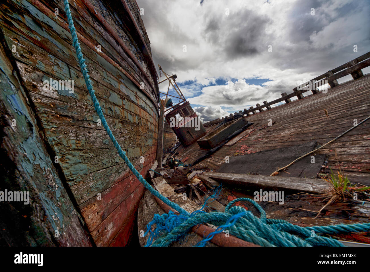 Une corde bleue liée à un vieux bateau en bois patiné sur un quai en bois ; Salem Ile de Mull ...