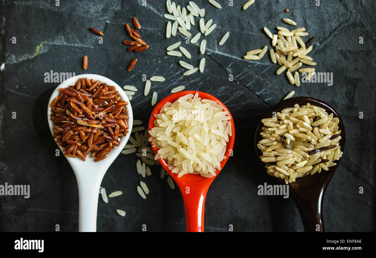 Différents types de riz dans les pots sur la table rustique Photo Stock ...